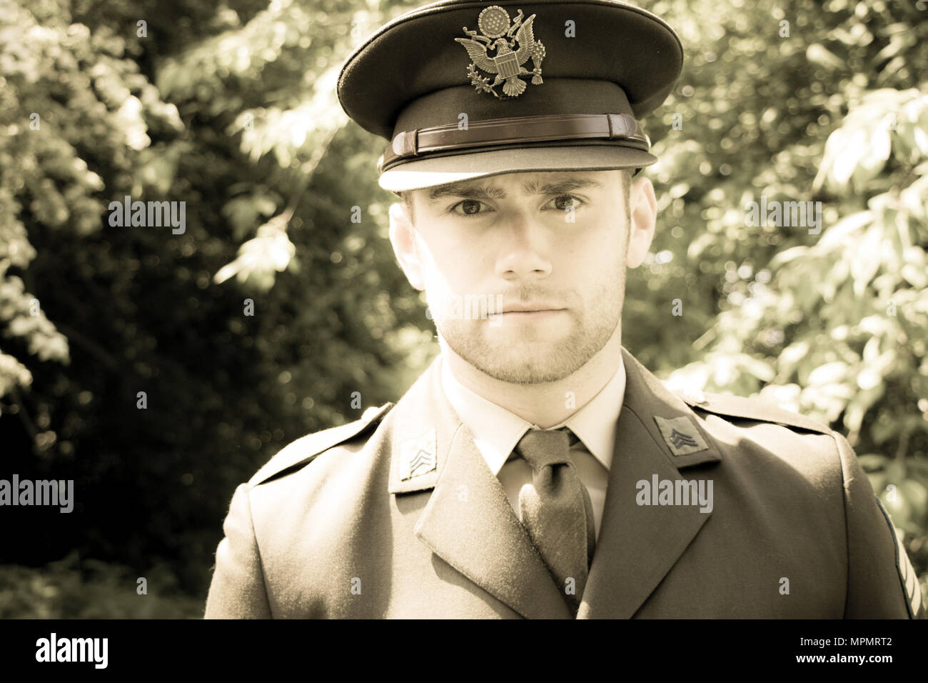 Handsome American WWII GI Army officer in uniform walking through woods ...