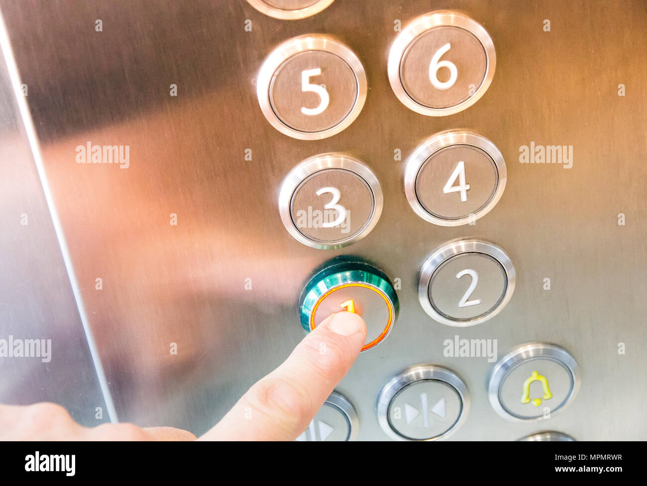 Finger presses on first floor in modern metal elevator business ...