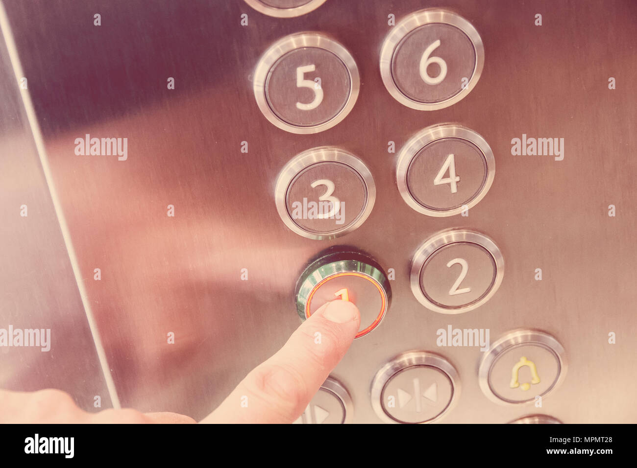 Finger presses on first floor in modern metal elevator business ...