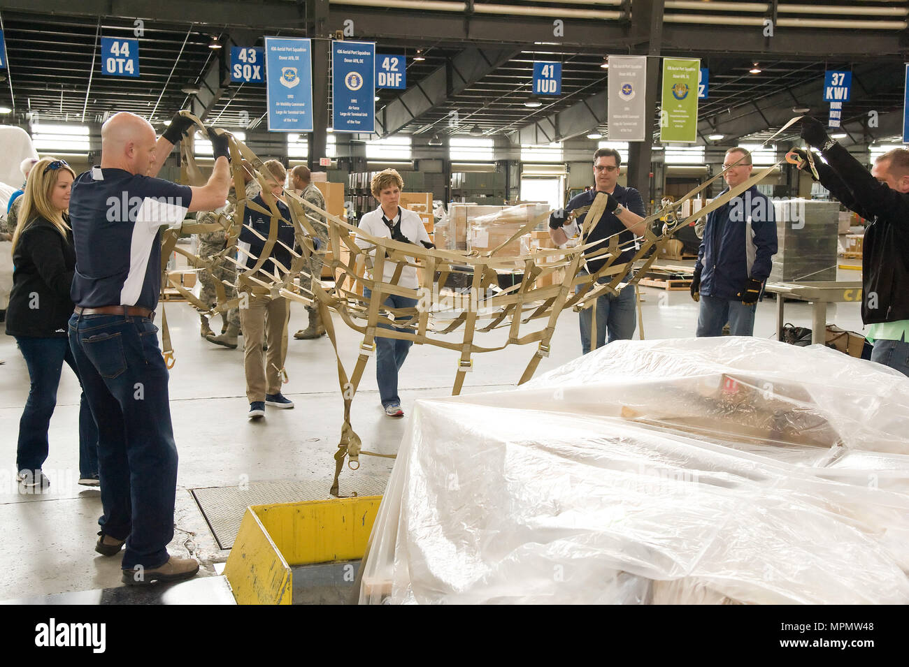 Team Dover Honorary Commanders position a cargo net over a pallet March ...