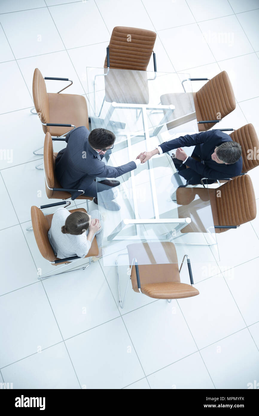 Handshake across the table. Meeting around a boardroom table Stock ...