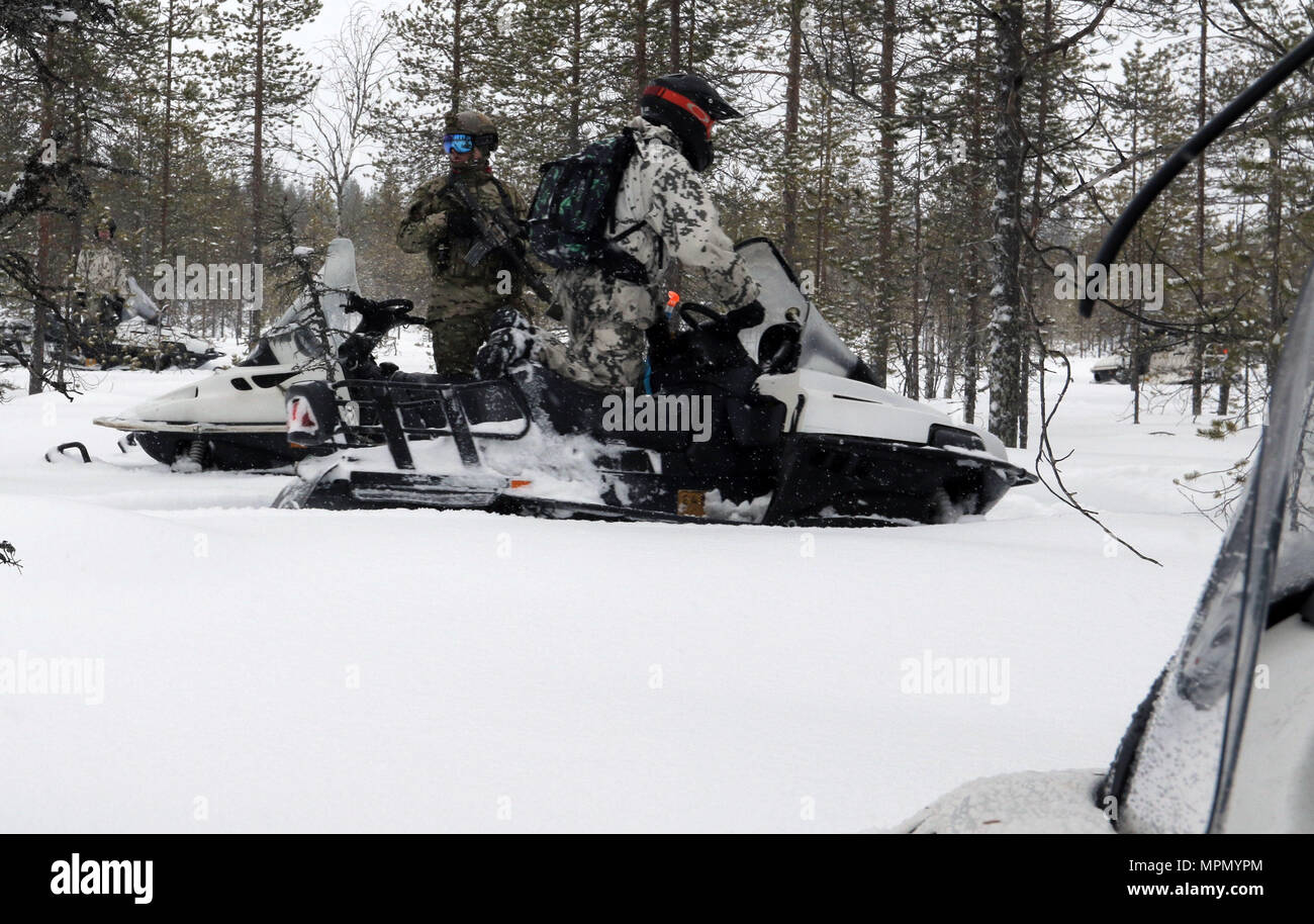 A Finnish Defense Force soldier drives a snowmobile past a 10th Special ...