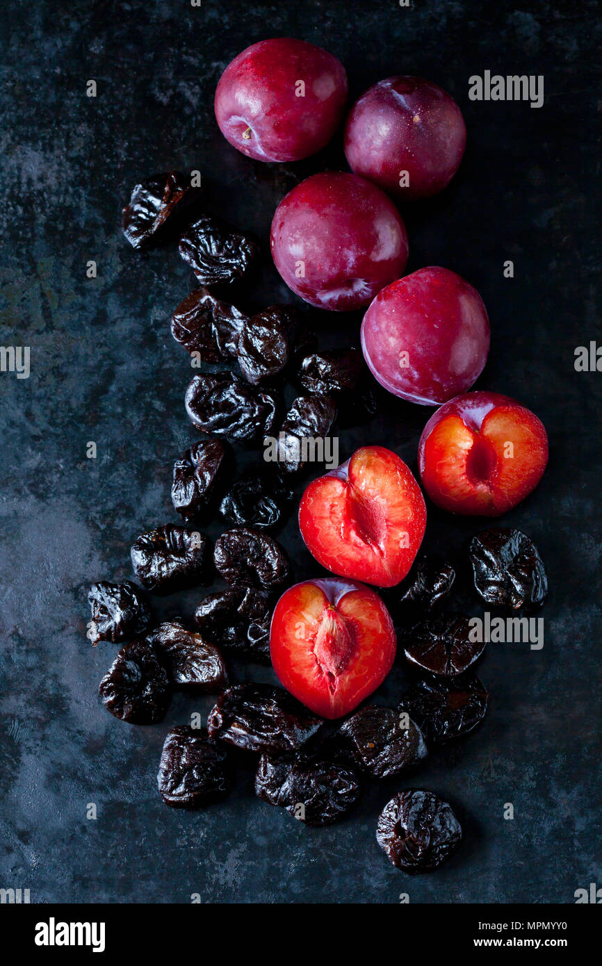 Fresh and dried plums on dark ground Stock Photo - Alamy