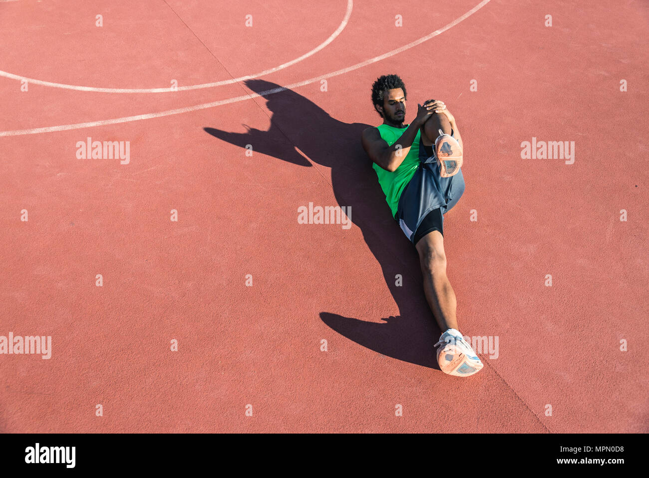 Young basketball player stretching leg Stock Photo - Alamy