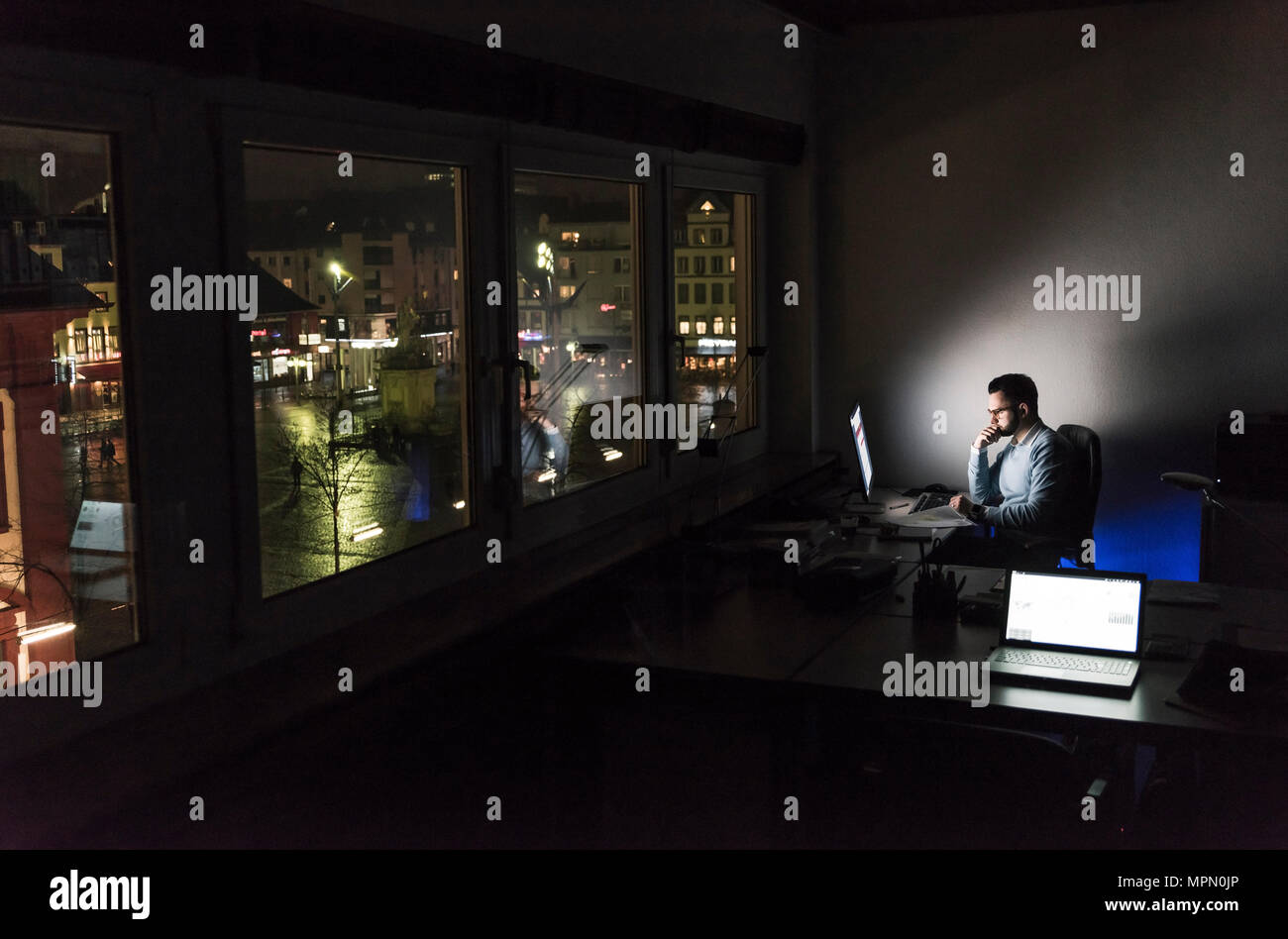 Businessman working on computer in office at night Stock Photo - Alamy