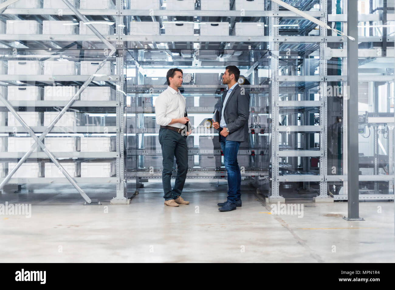 Two businessmen talking in modern factory Stock Photo - Alamy