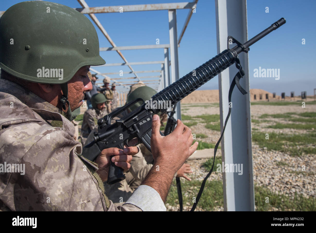 An Iraqi security forces soldier loads a magazine during an M16 rifle ...