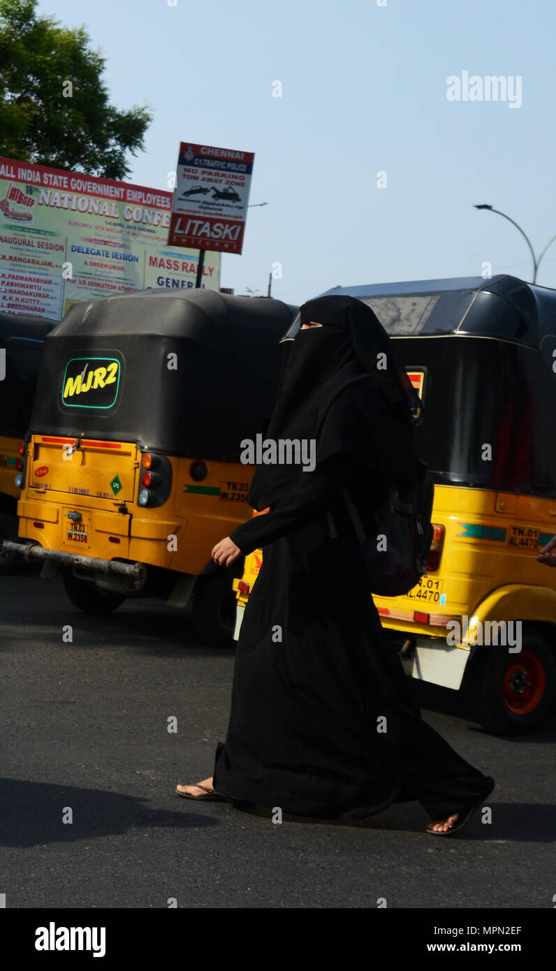A veiled Muslim woman walking by auto rickshaws in Chennai, India Stock ...