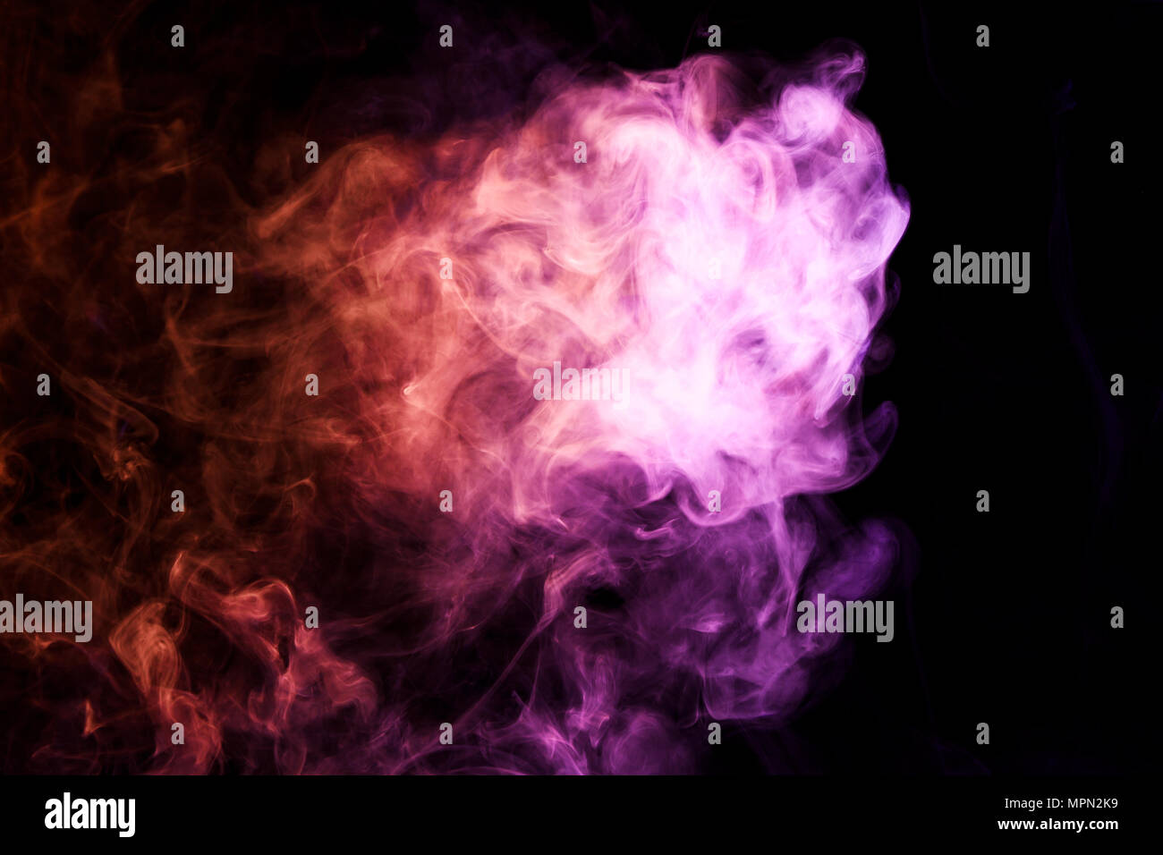 Colorful red and pink a smoke on a black isolated background ...