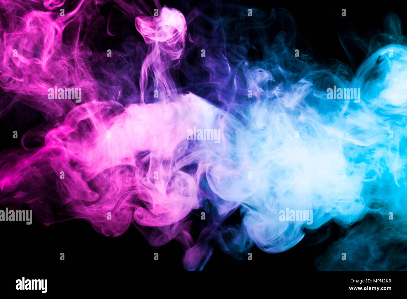 Thick colorful smoke of pink, blue on a black isolated background ...