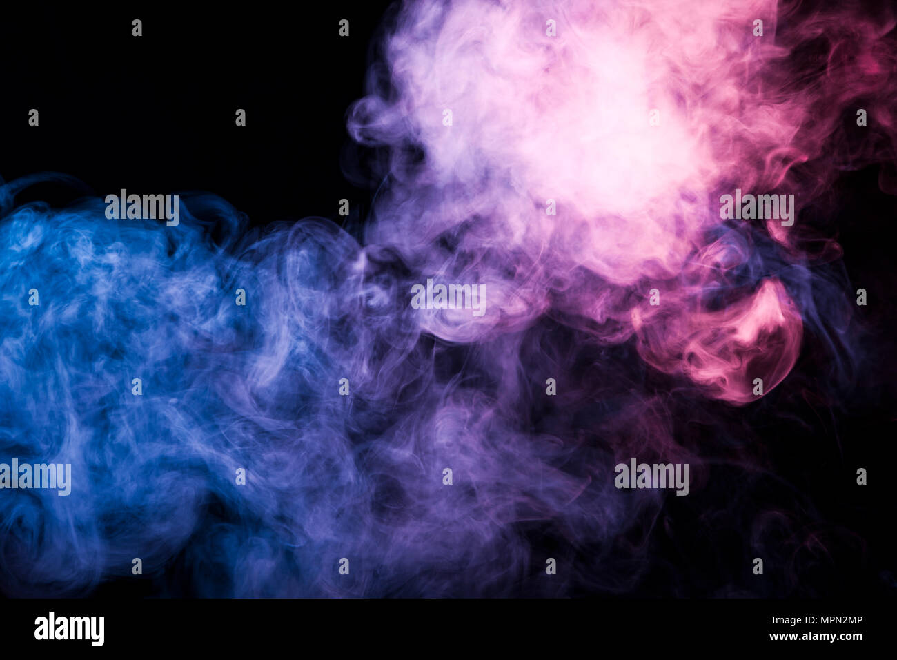 Thick colorful smoke of pink, blue on a black isolated background ...