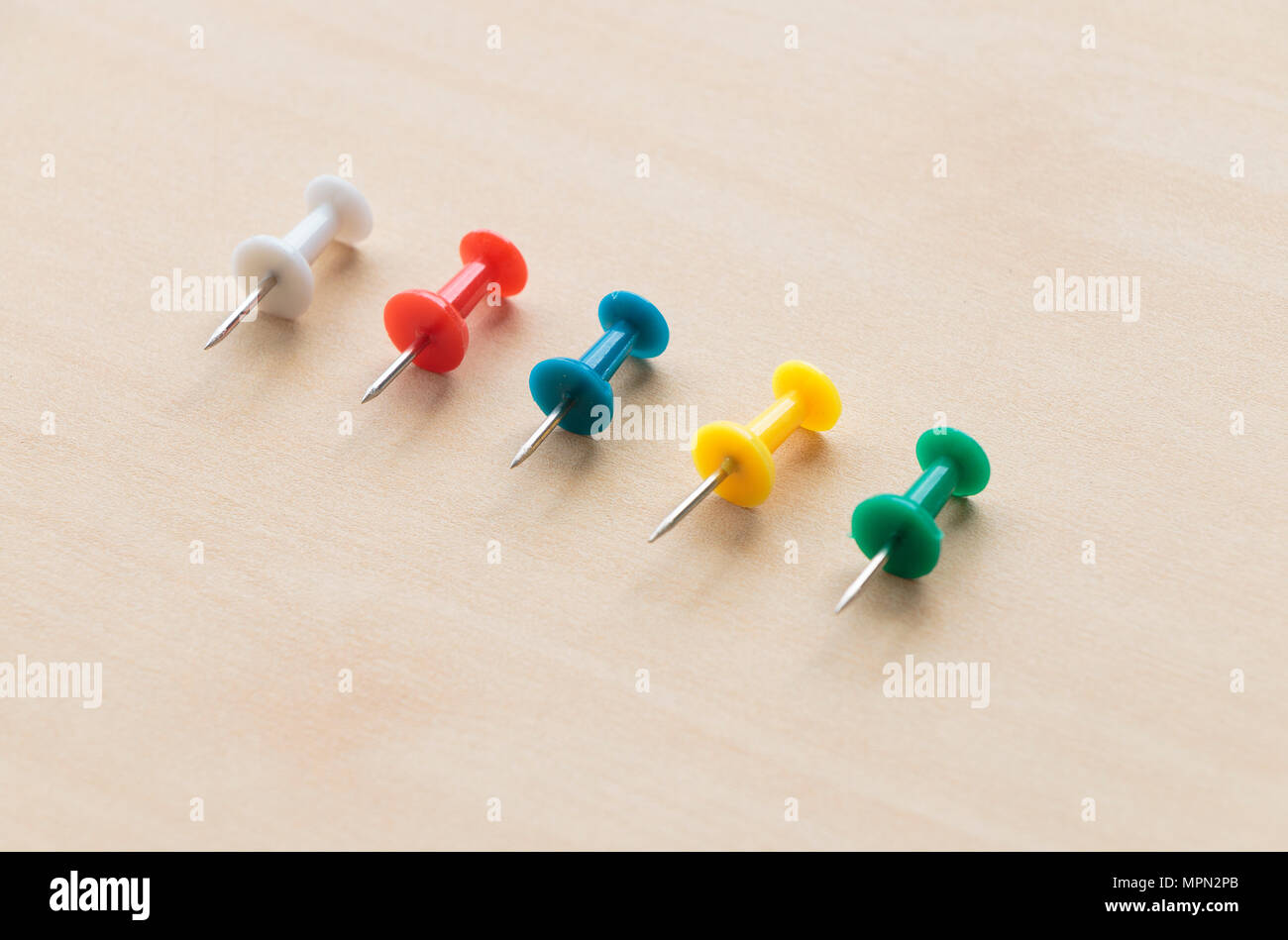 Colorful pin put on wooden table top background Stock Photo - Alamy
