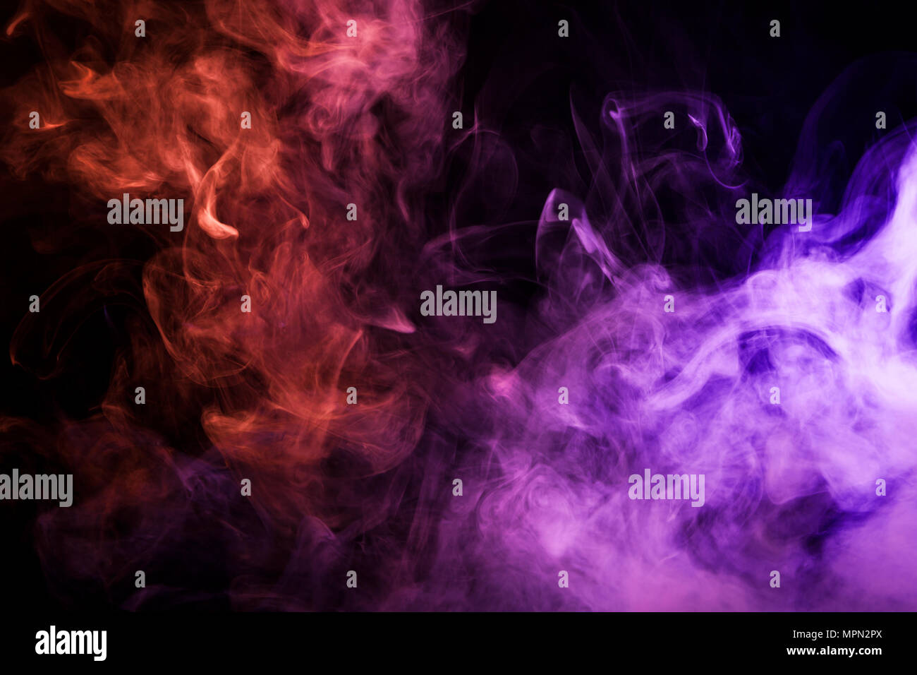 Dense multicolored smoke of pink and red colors on a black isolated ...