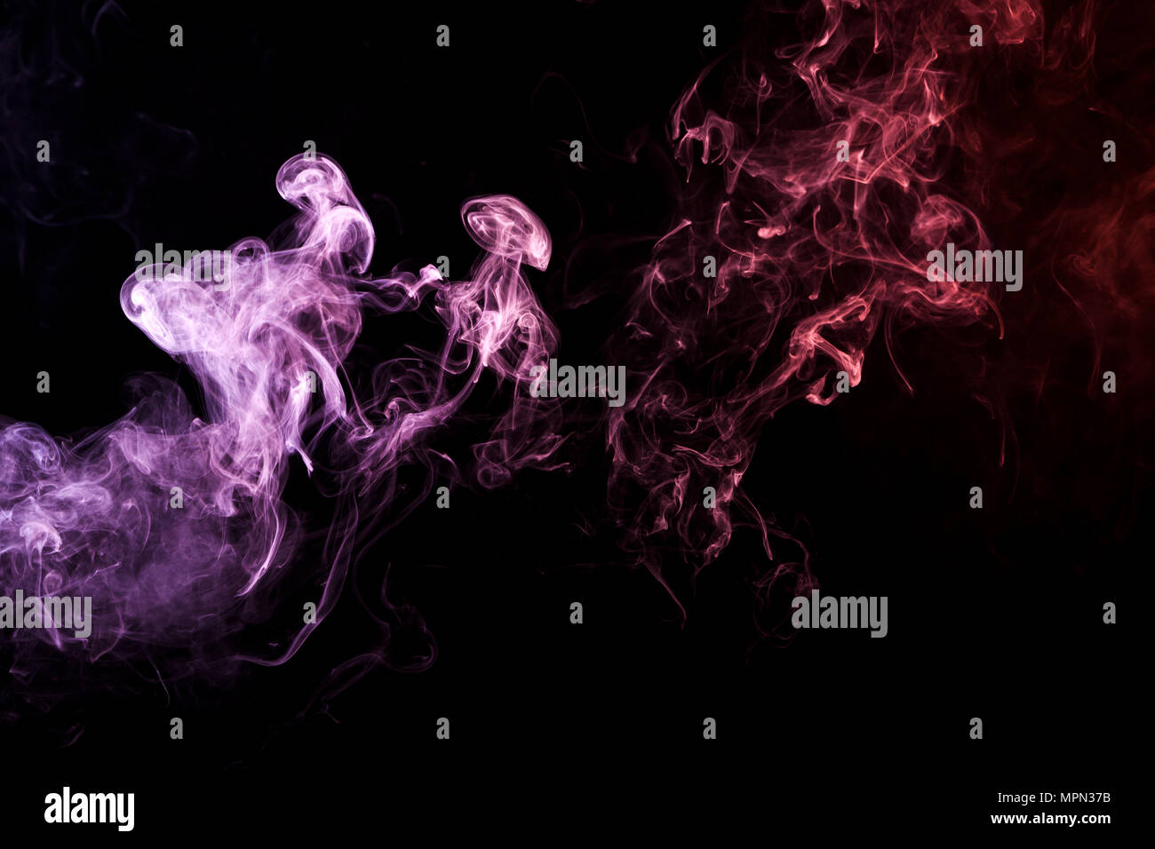 Dense multicolored smoke of pink and red colors on a black isolated ...