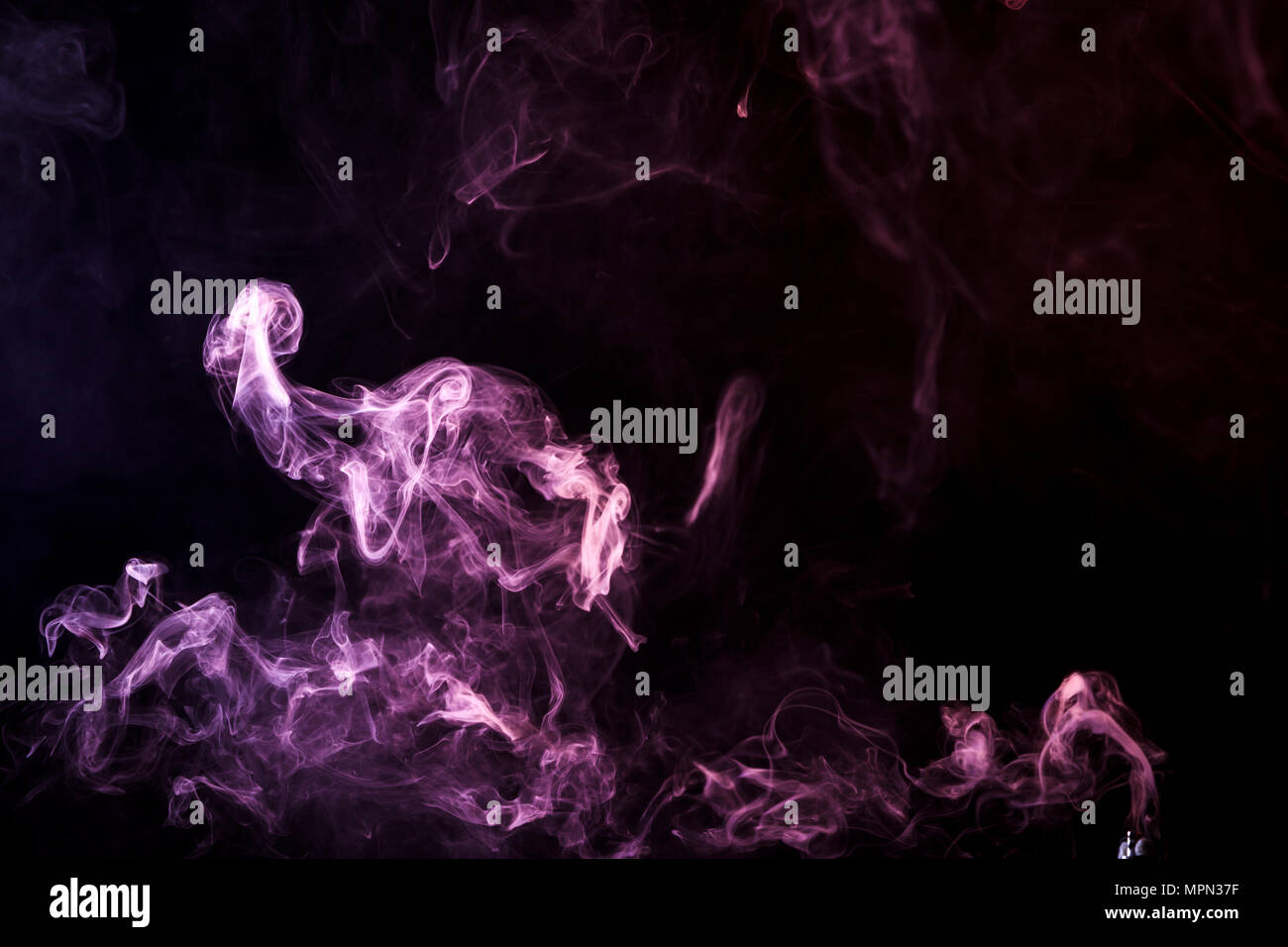 Dense multicolored smoke of pink and red colors on a black isolated ...