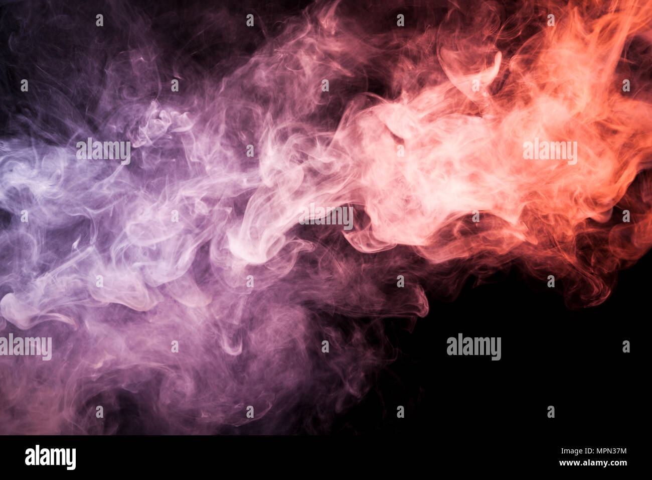 Dense multicolored smoke of pink and red colors on a black isolated ...