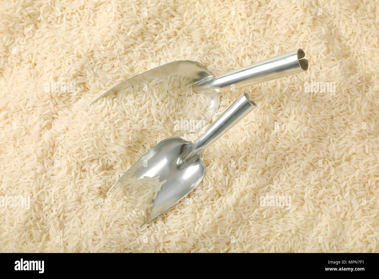 two scoops of white long grained rice on rice background Stock Photo ...