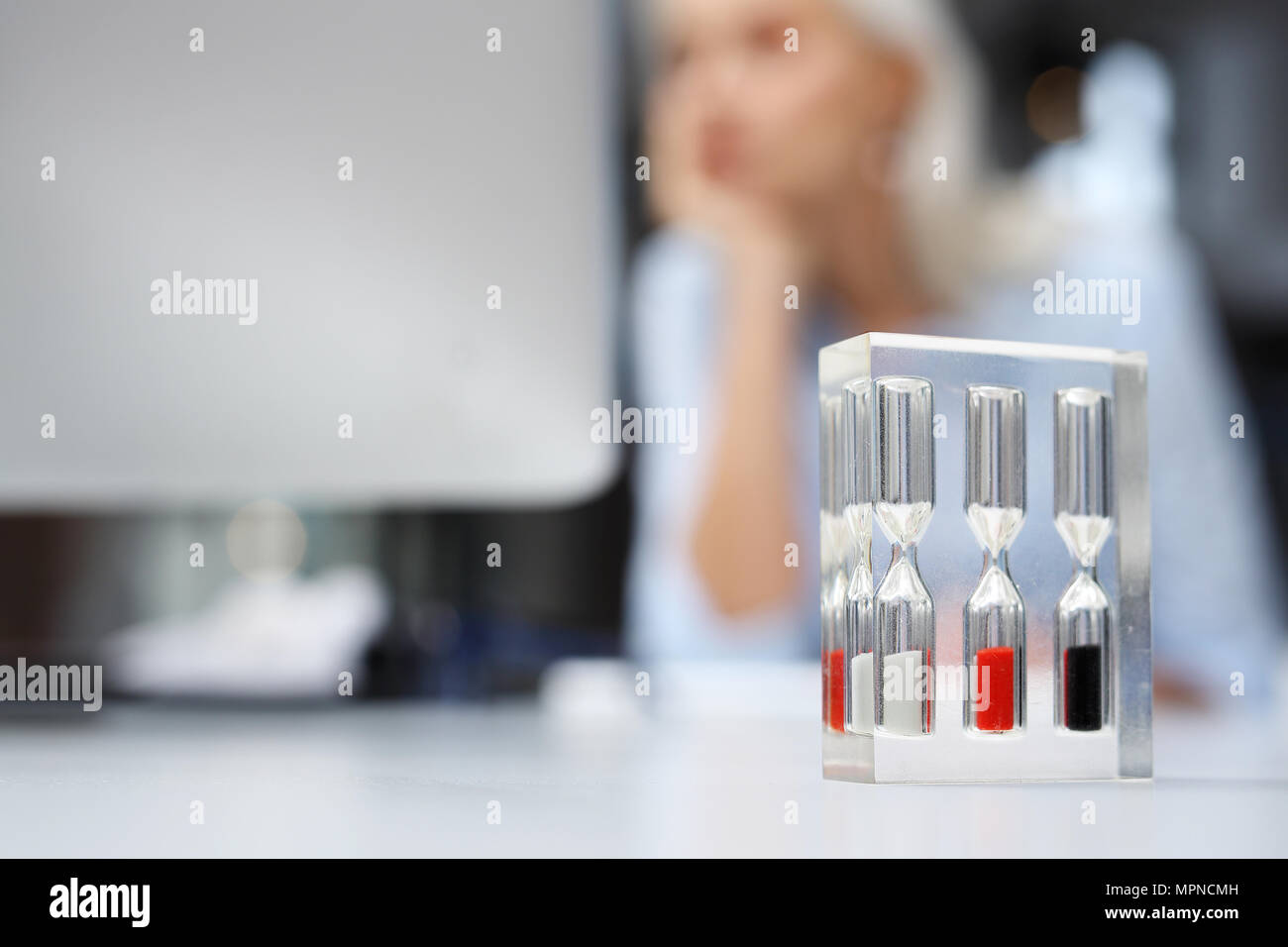 Working hours, the woman deducts time spent at the desk. The hourglass ...