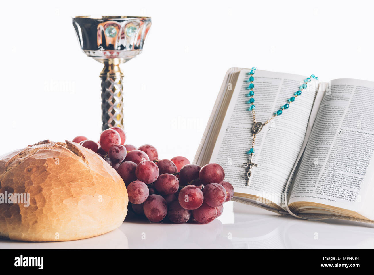 open holy bible, food, chalice and christian cross on white for Holy ...