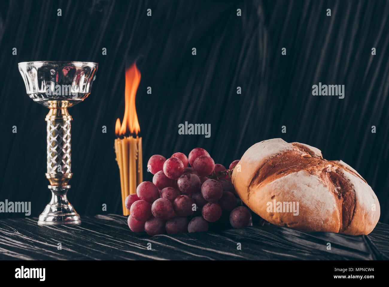 bread with grapes, chalice and candles on black fabric, Holy Communion ...