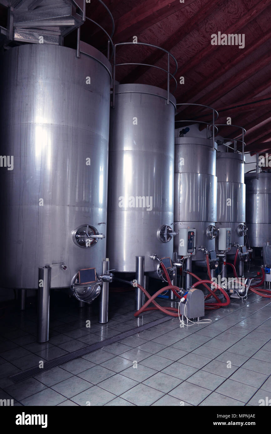 Stainless steel wine vats in a row inside the winery Stock Photo - Alamy