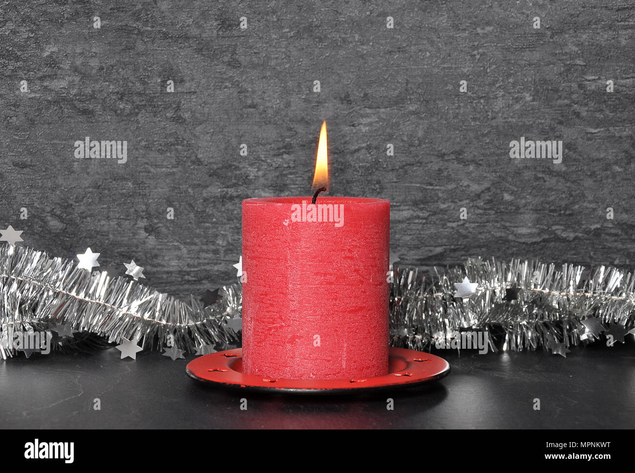 Burning candle on shale Stock Photo - Alamy