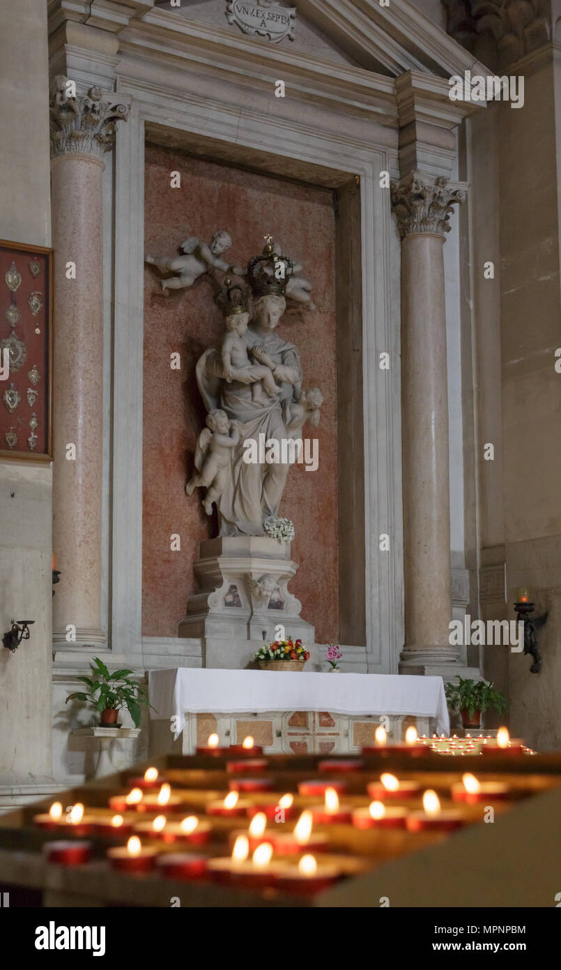 Votive Candles with Statue in Background Stock Photo - Alamy