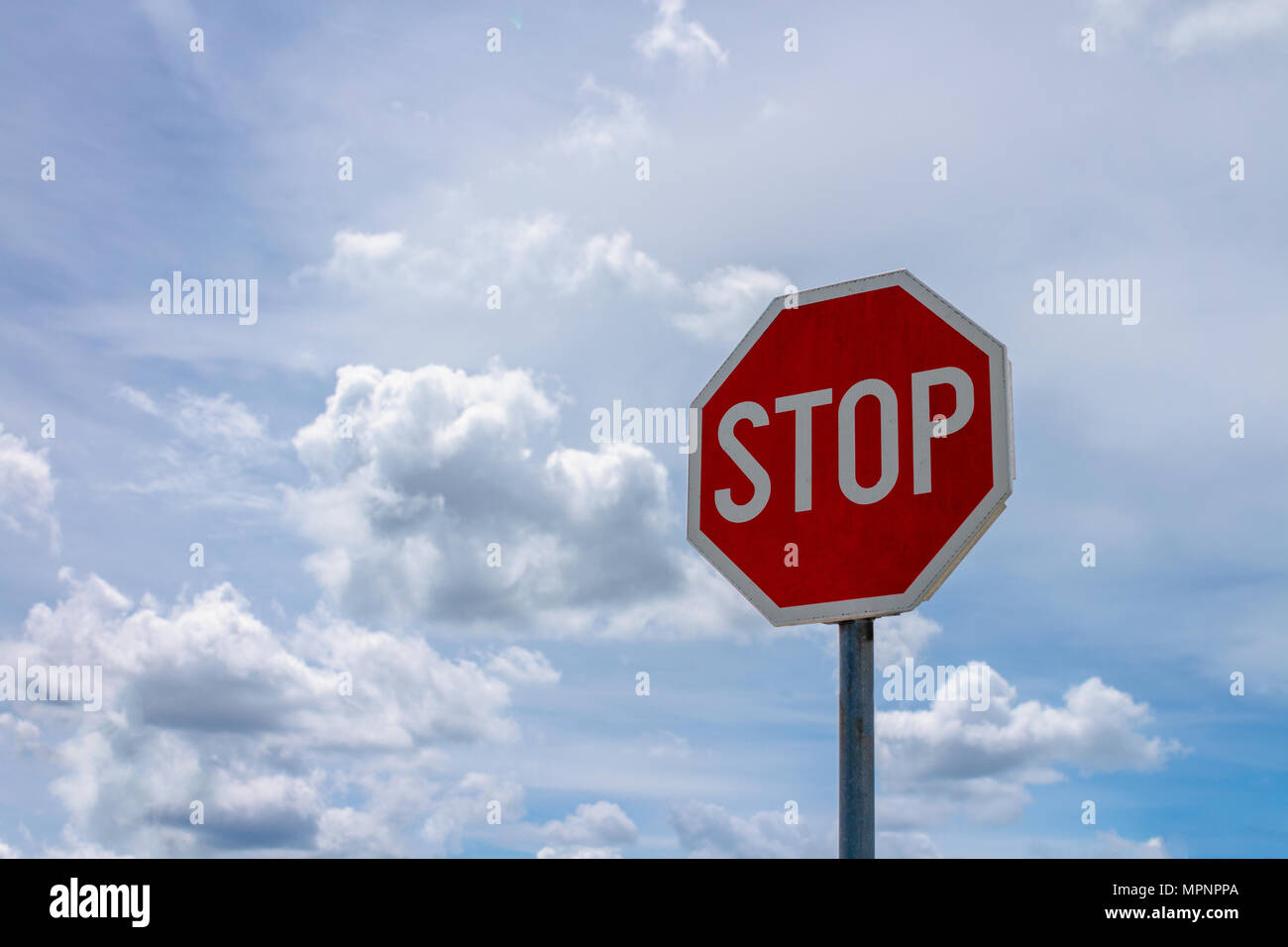 Red stop sign and blue sky with white clouds in background Stock Photo ...