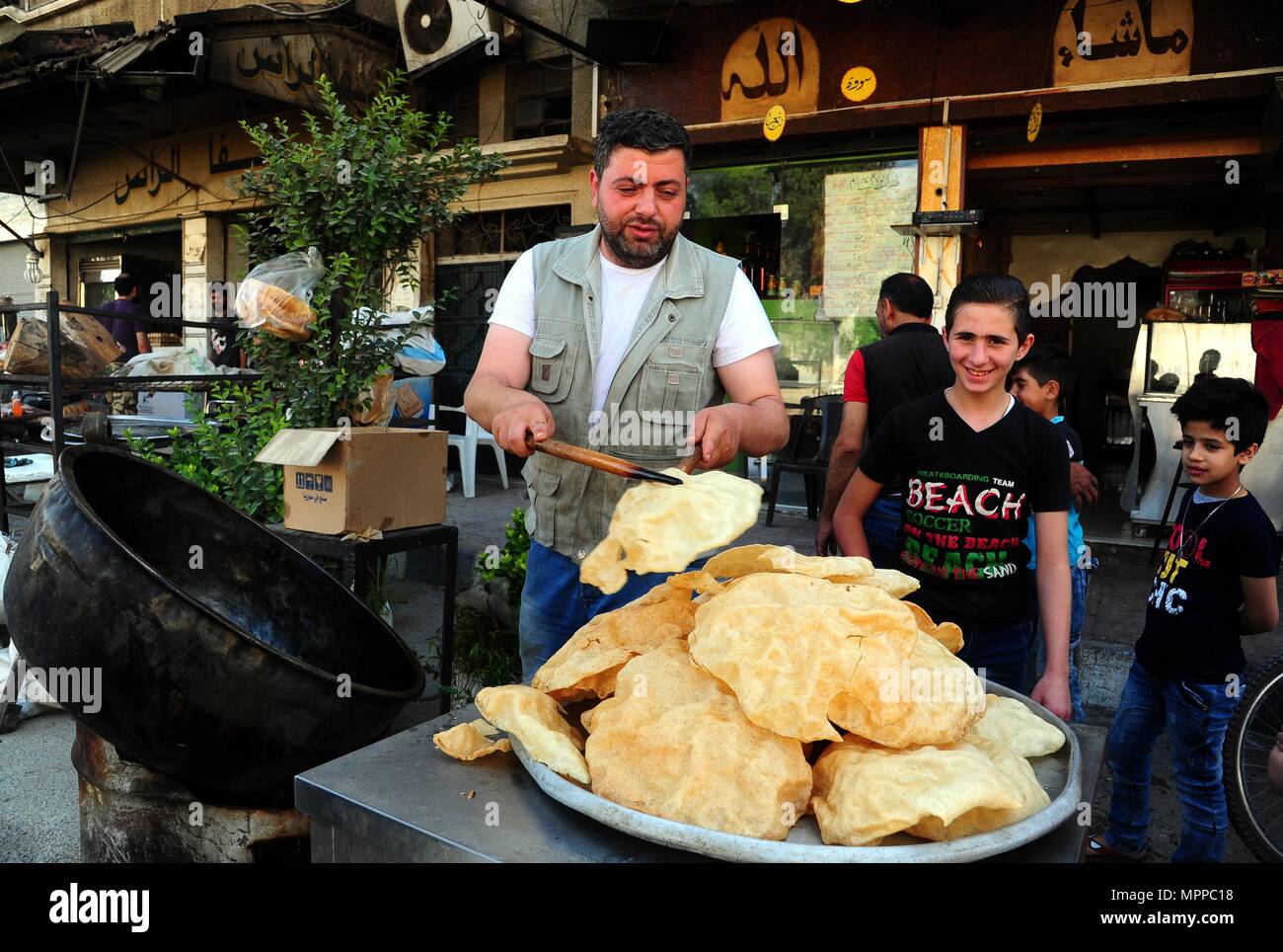Damascus, Syria. 24th May, 2018. A street vendor prepares Naem cake, a ...