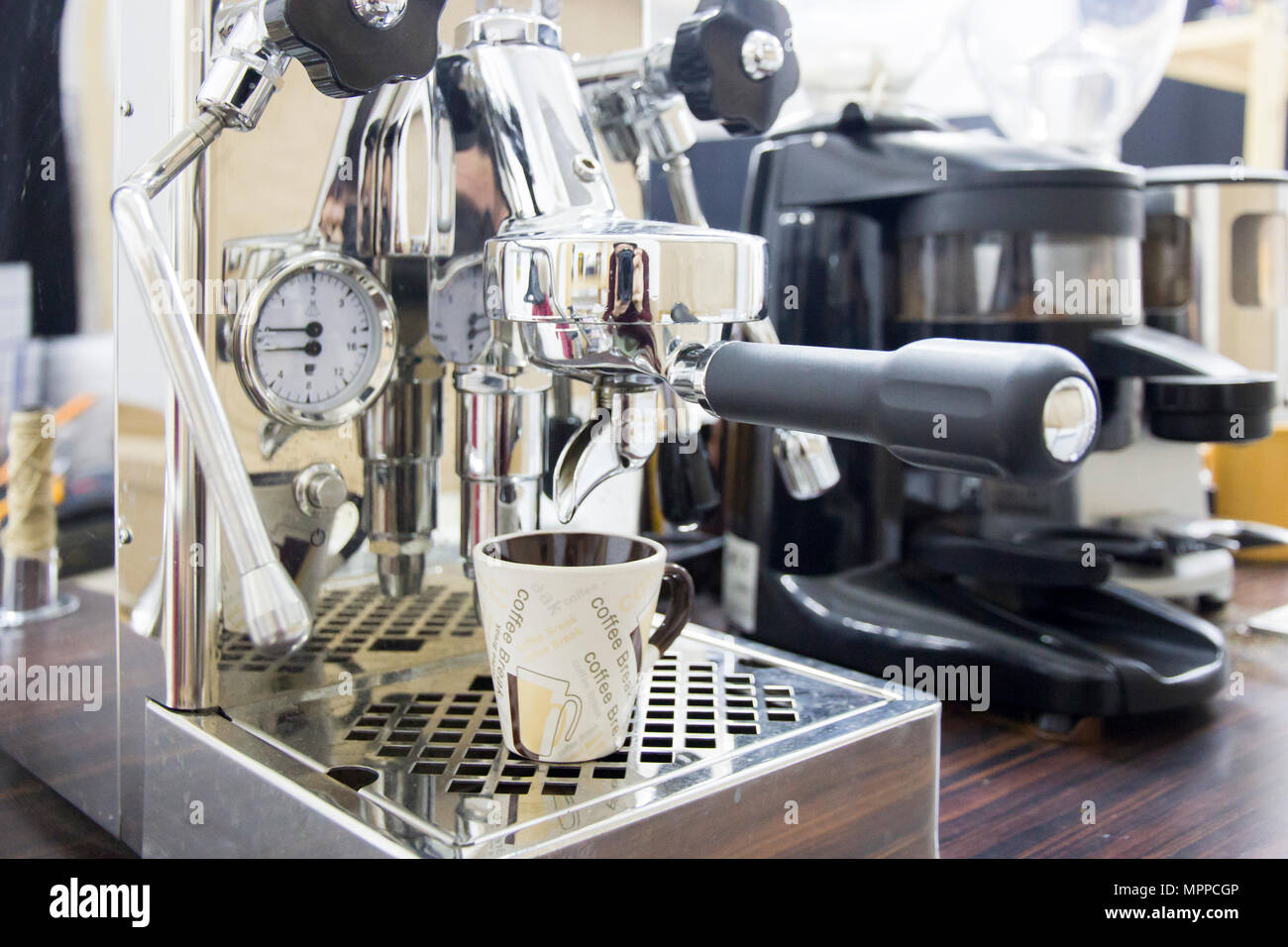 Modern metal coffee machine stands empty coffee cup Stock Photo - Alamy