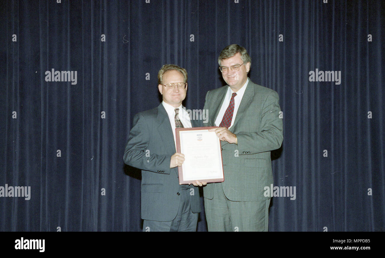Two men holding an award certificate Stock Photo - Alamy