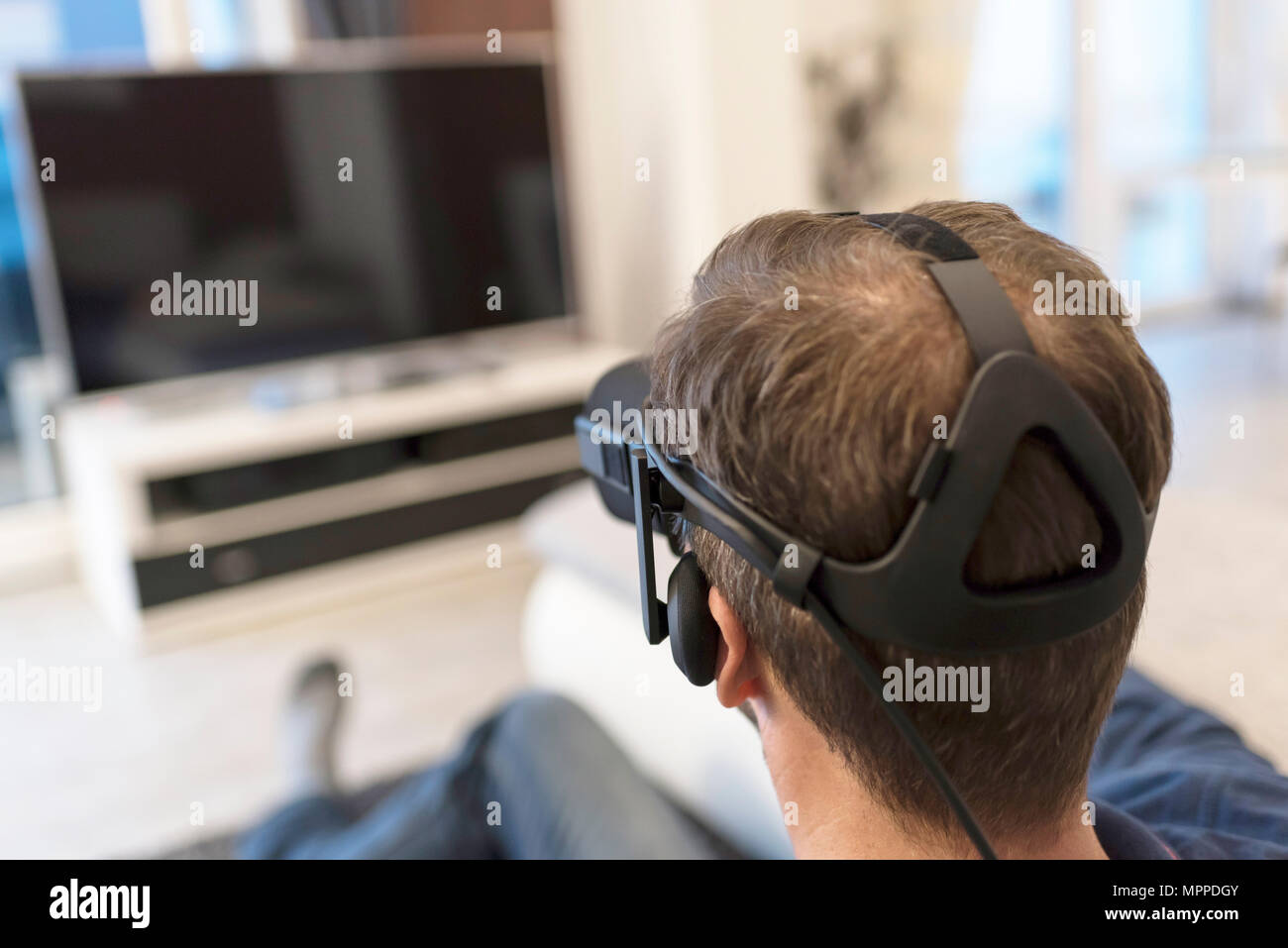 Man wearing VR glasses watching Tv Stock Photo - Alamy