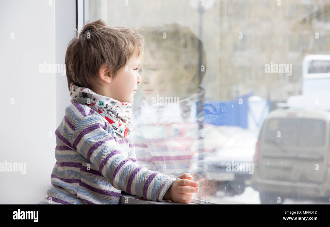 Handsome boy smiling to someone in window Stock Photo - Alamy