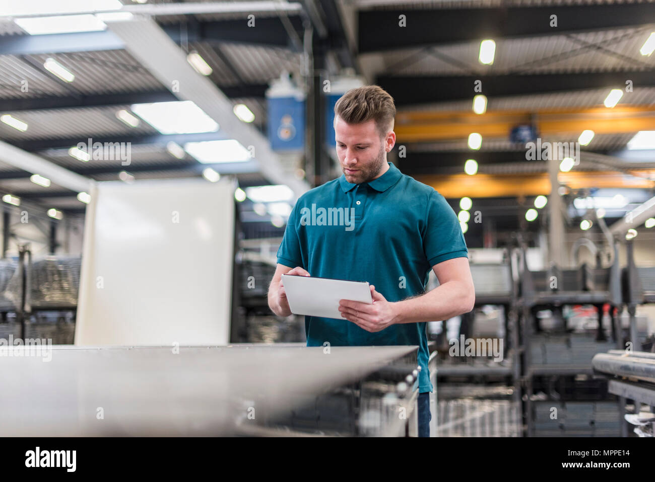 Man using tablet on factory shop floor Stock Photo - Alamy