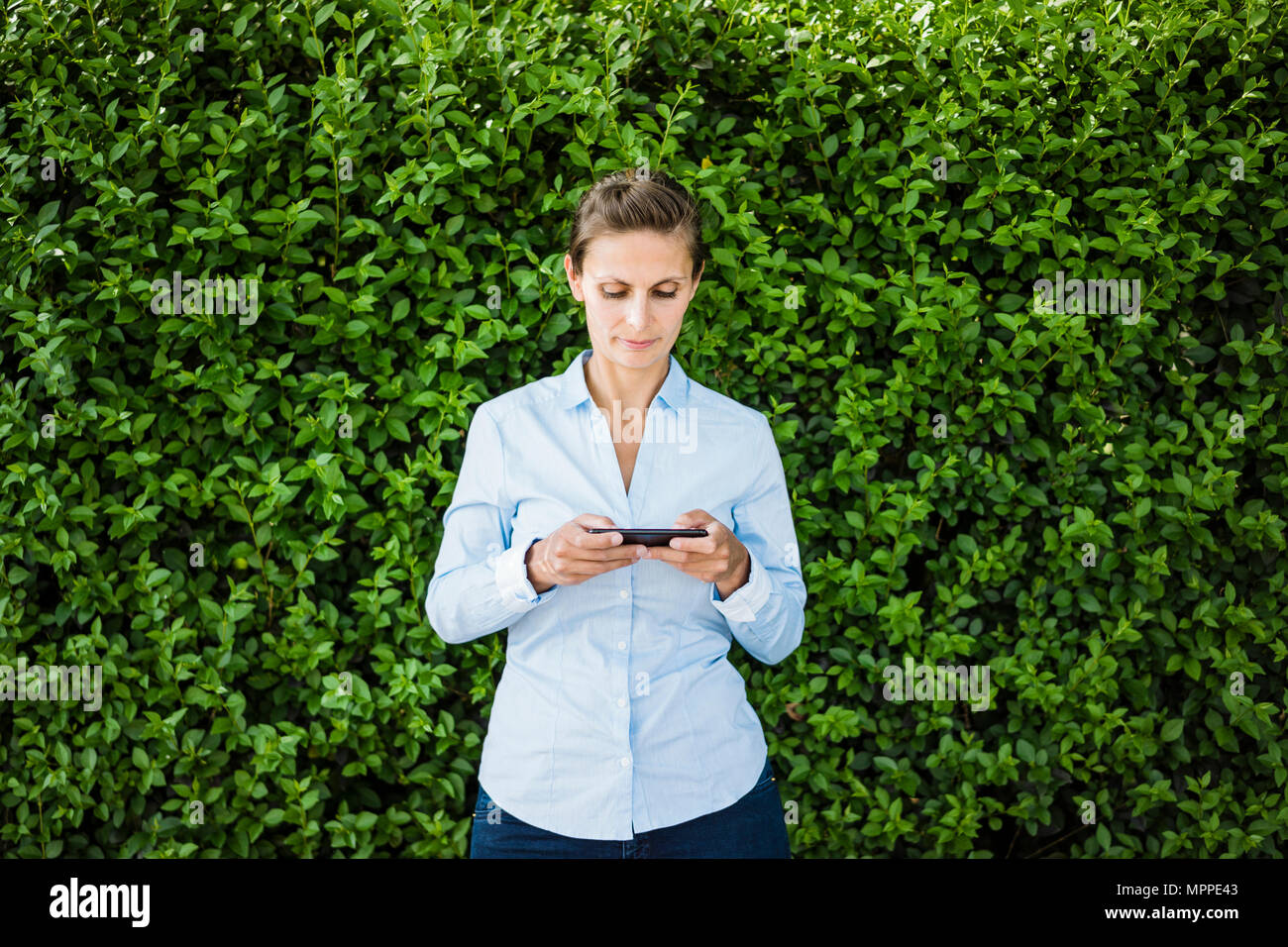 Woman standing using phone hi-res stock photography and images - Alamy