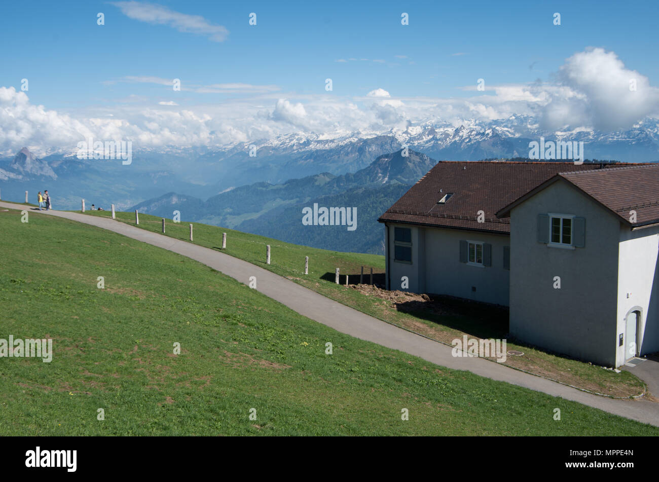 House at the top of mount rigi surrounded by green grass and the alps ...