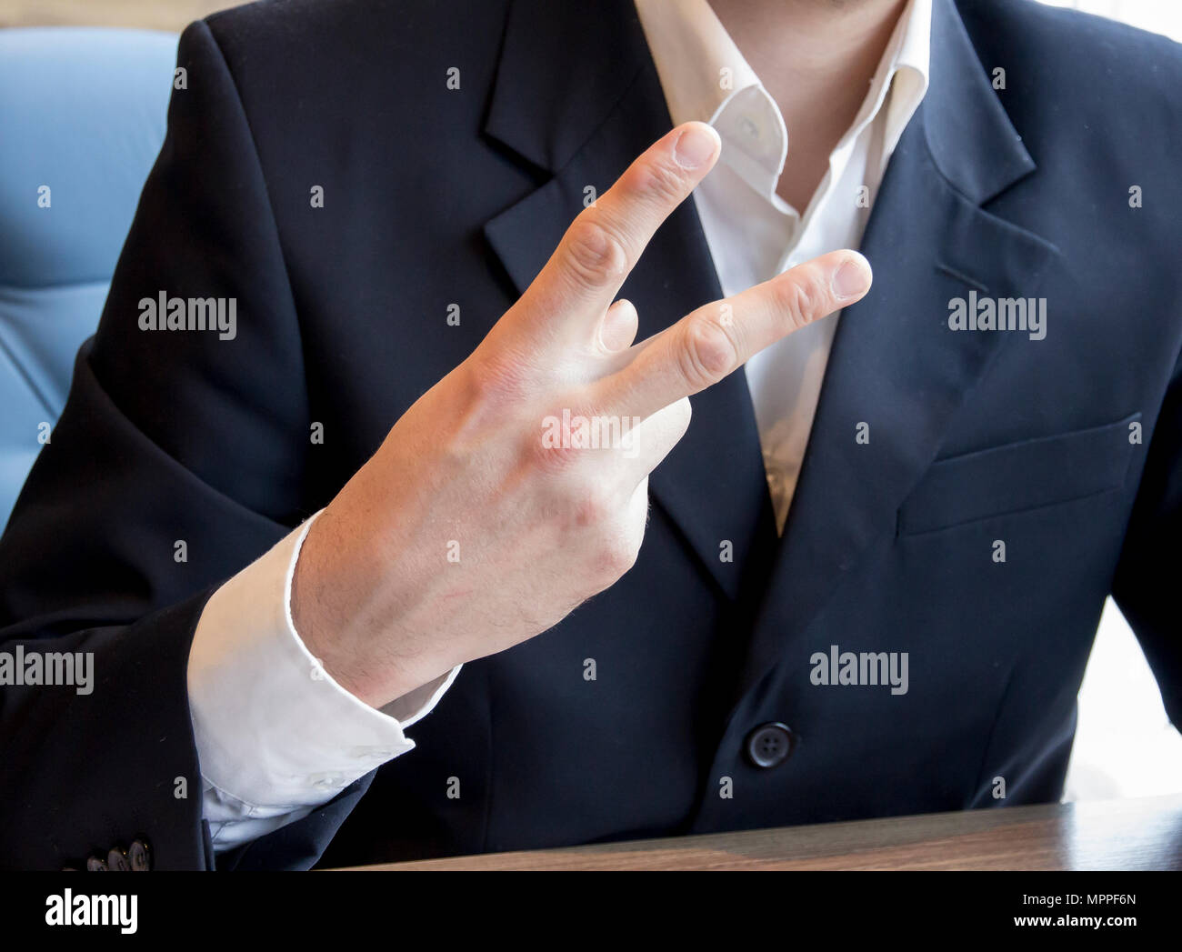 Men's hand showing victory sign Stock Photo - Alamy