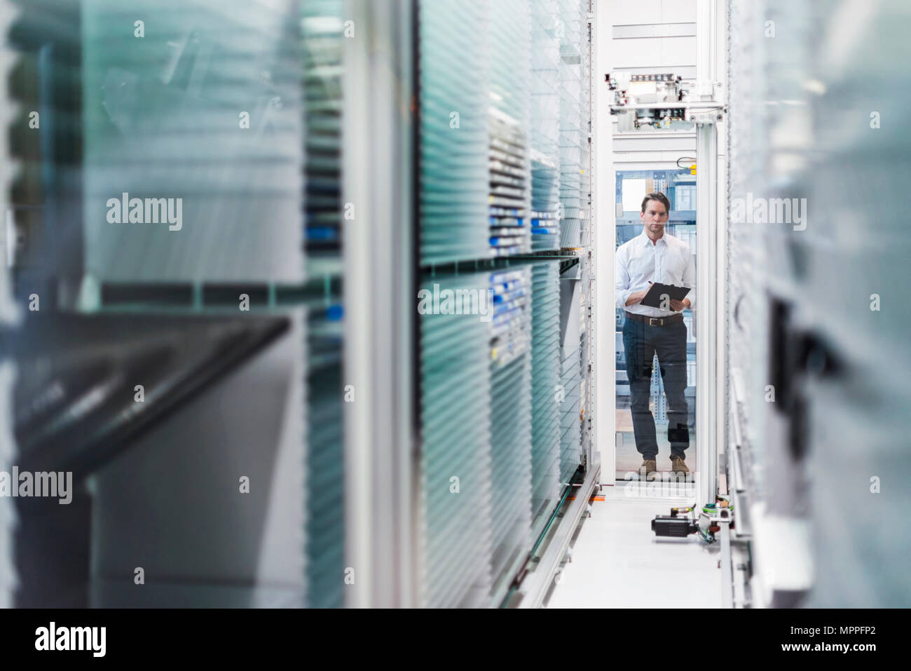 Man with clipboard in modern factory Stock Photo - Alamy