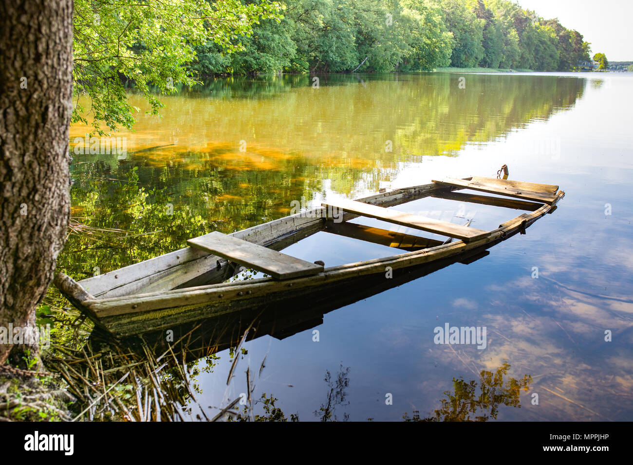 Masurian lake and a fishing boot. Colorful leaves, blue water and sunny ...