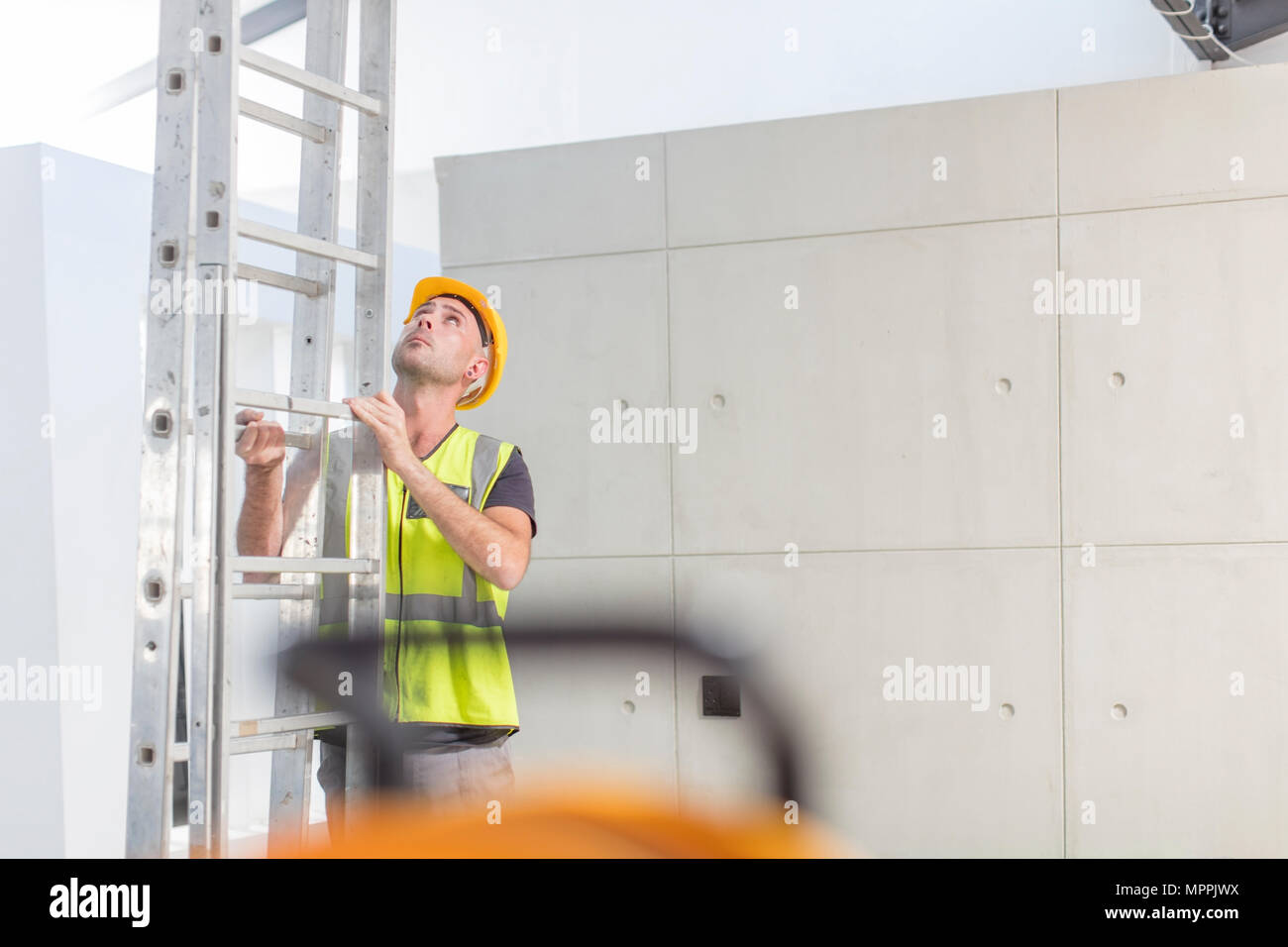 Construction worker holding ladder Stock Photo - Alamy