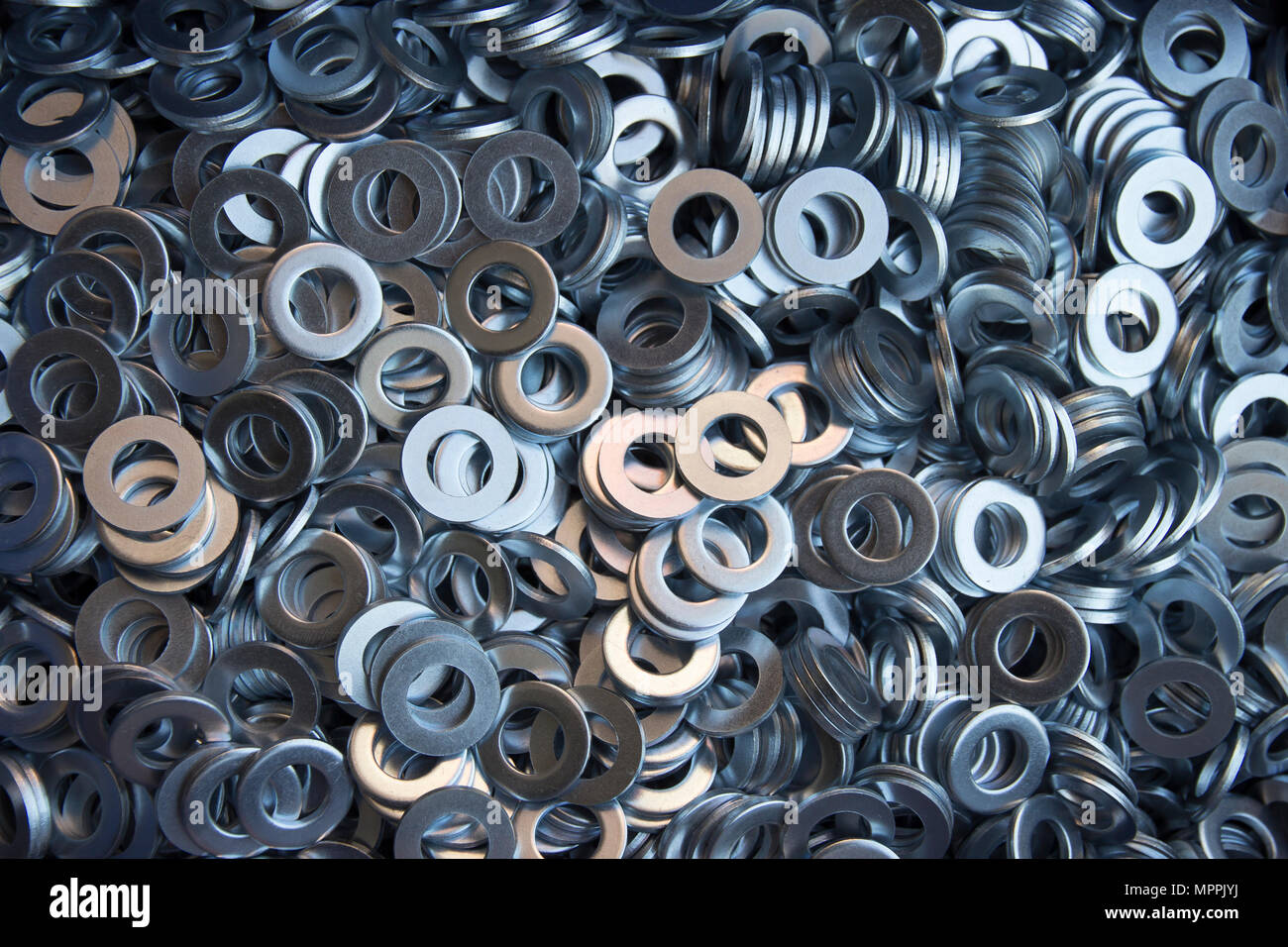 Many round metal washers on nut macro Stock Photo - Alamy