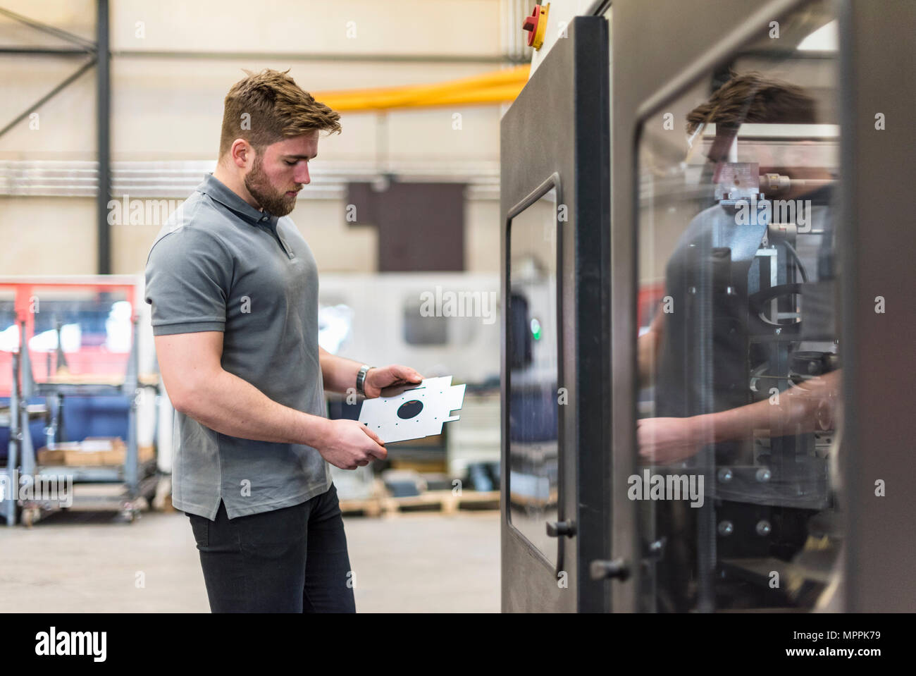 Man examining workpiece on factory shop floor Stock Photo - Alamy