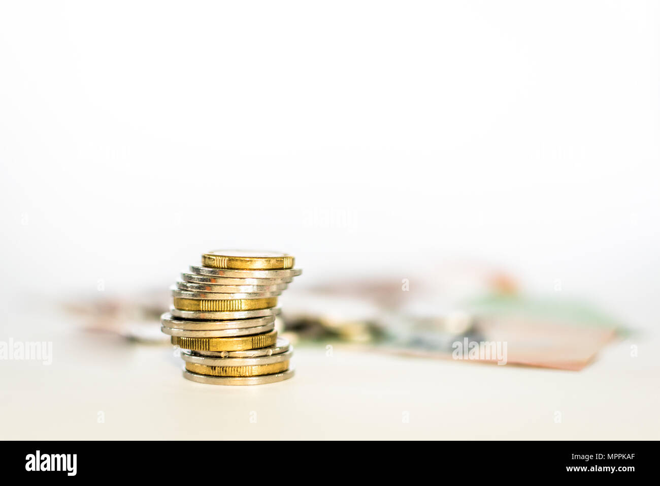 Stacked coins and notes on white background Stock Photo - Alamy