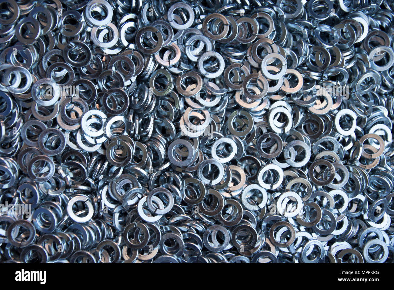 Many round metal washers on nut macro Stock Photo - Alamy