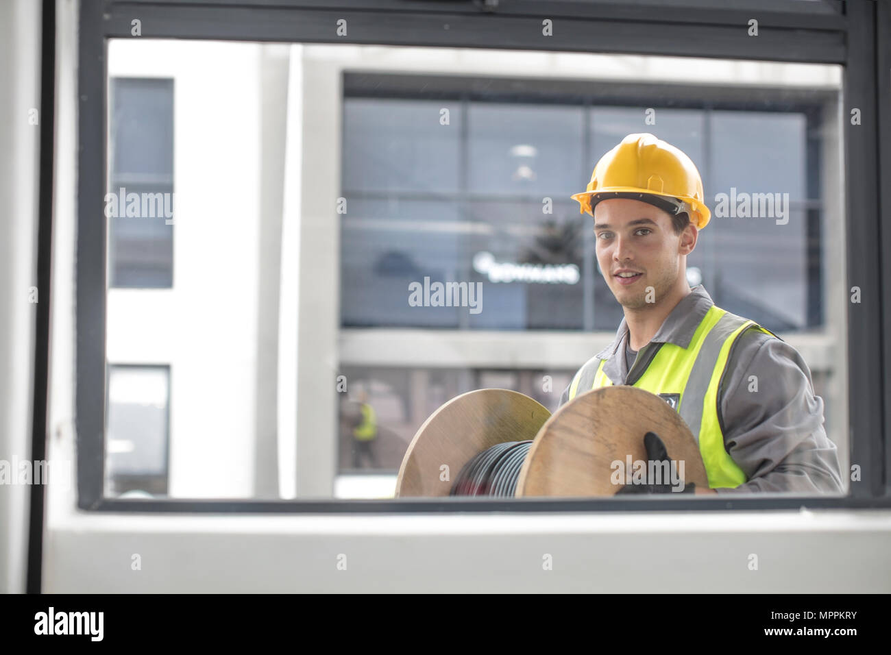 Portrait construction worker carrying cable drum hi-res stock ...