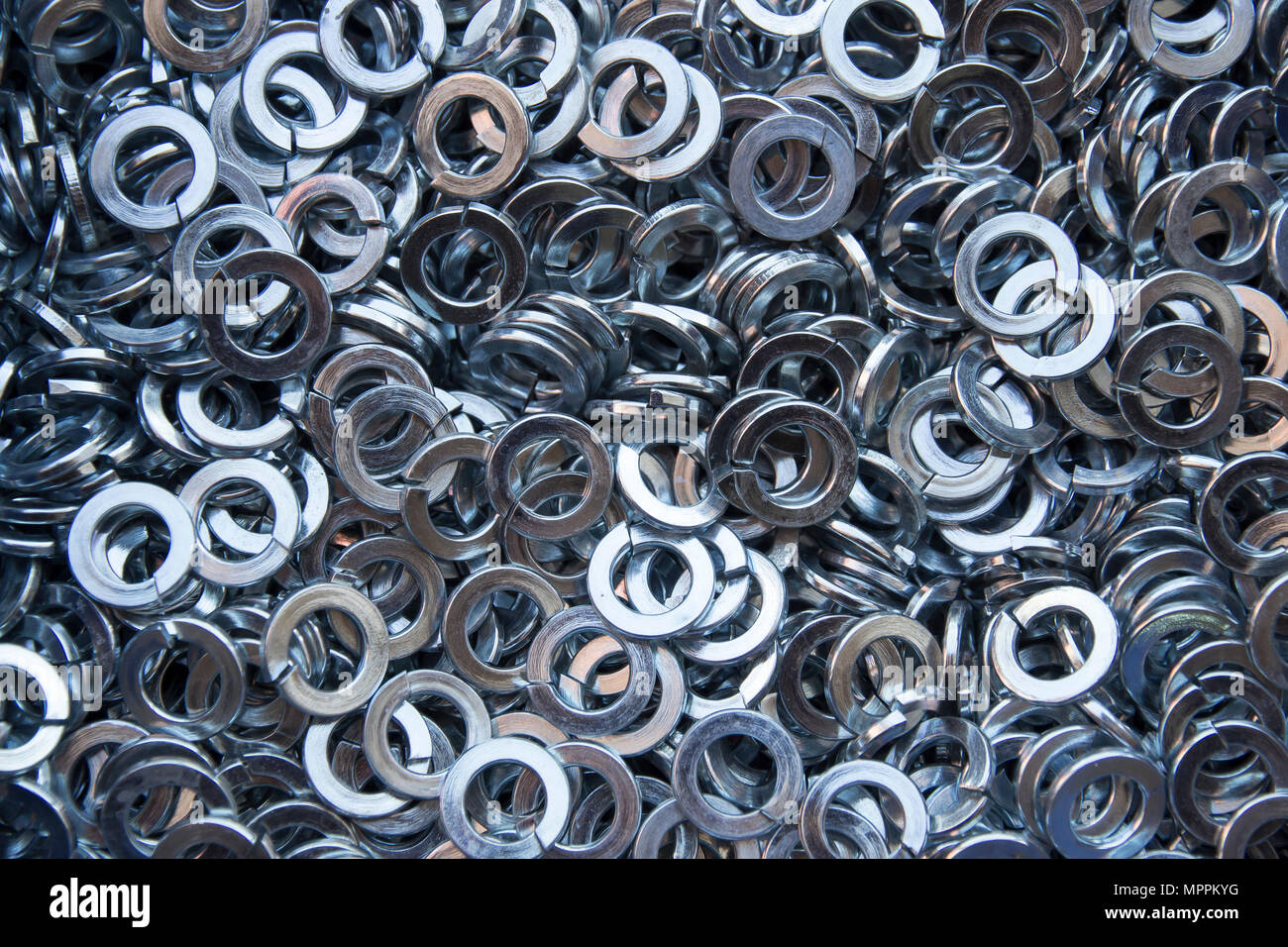 Many round metal washers on nut macro Stock Photo - Alamy