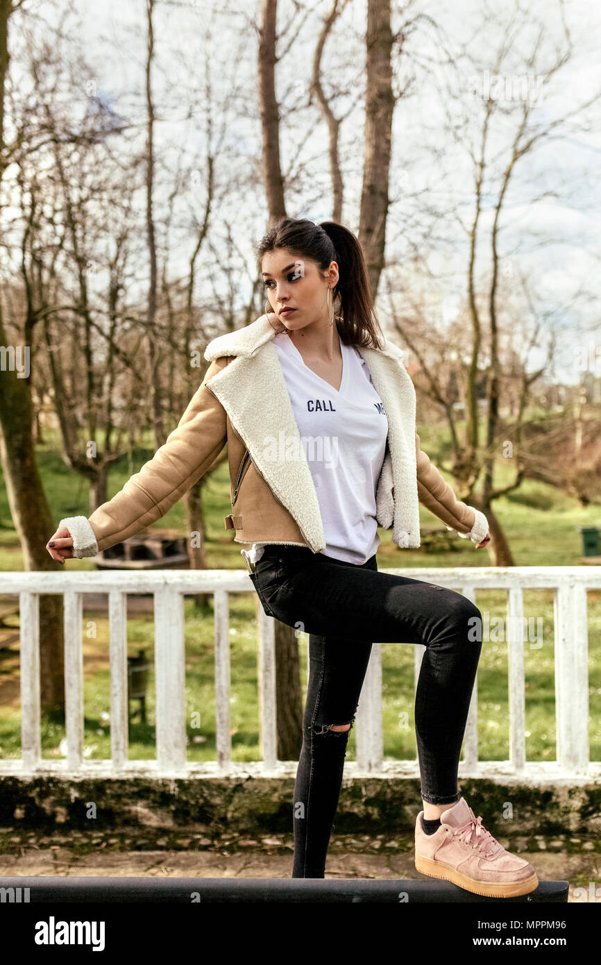 Beautiful young woman outdoors looking around Stock Photo - Alamy