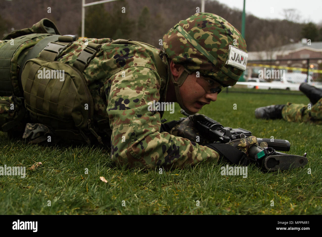 A Japanese army cadet competes in a low-crawl event during the 2017 ...