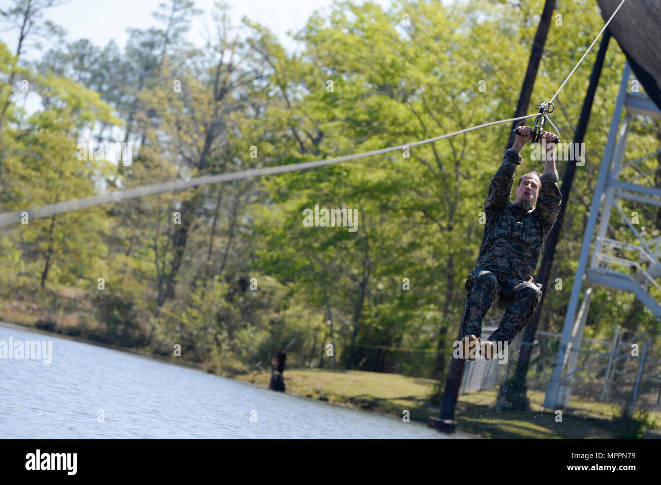A U.S. Army Ranger zip-lines into Victory Pond during the combat water ...