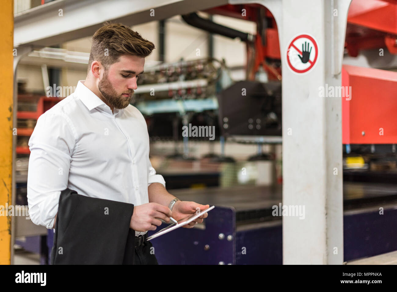 Man using tablet on factory shop floor Stock Photo - Alamy